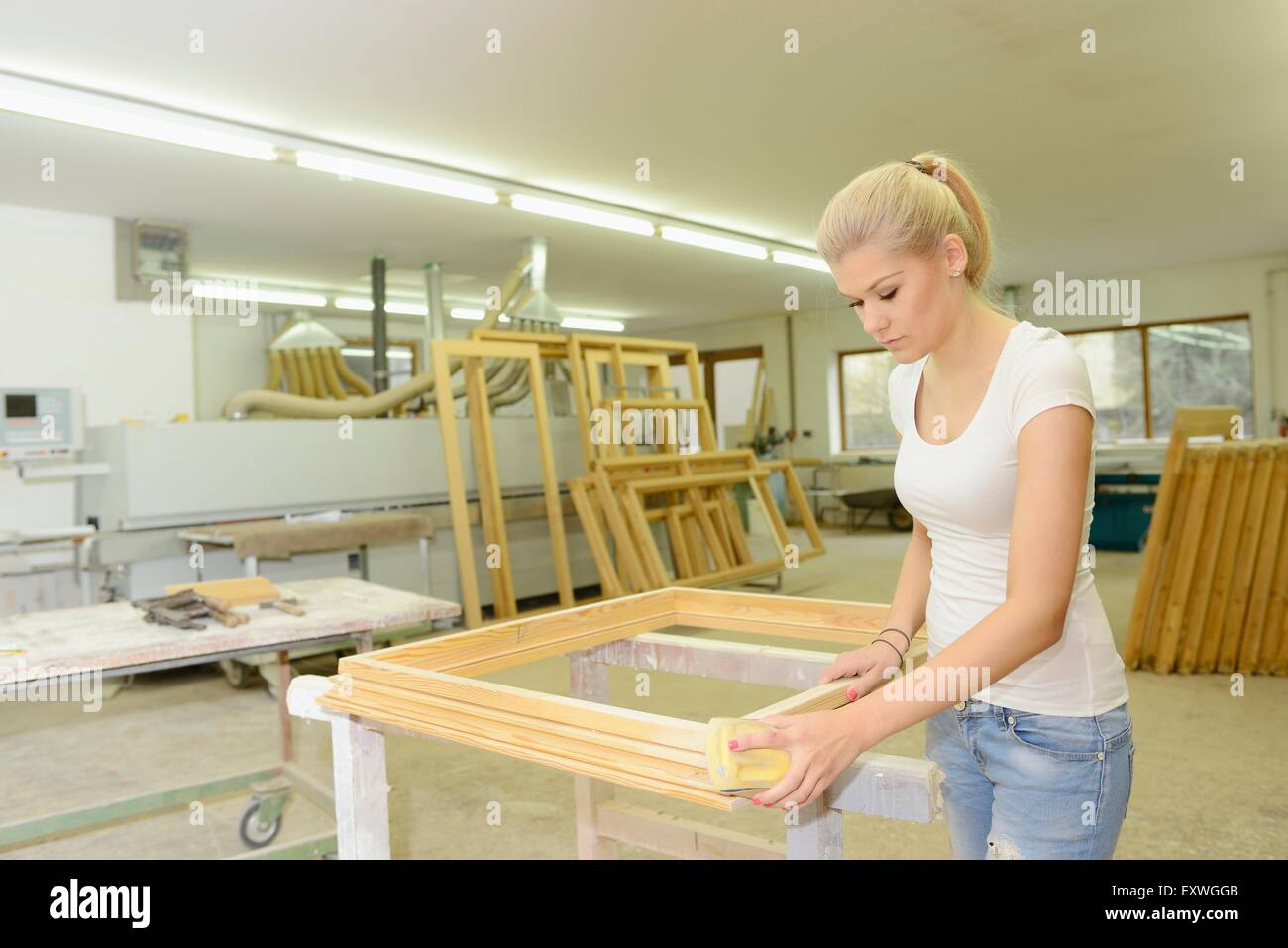 Young woman in a carpentry working on a window frame Stock Photo - Alamy