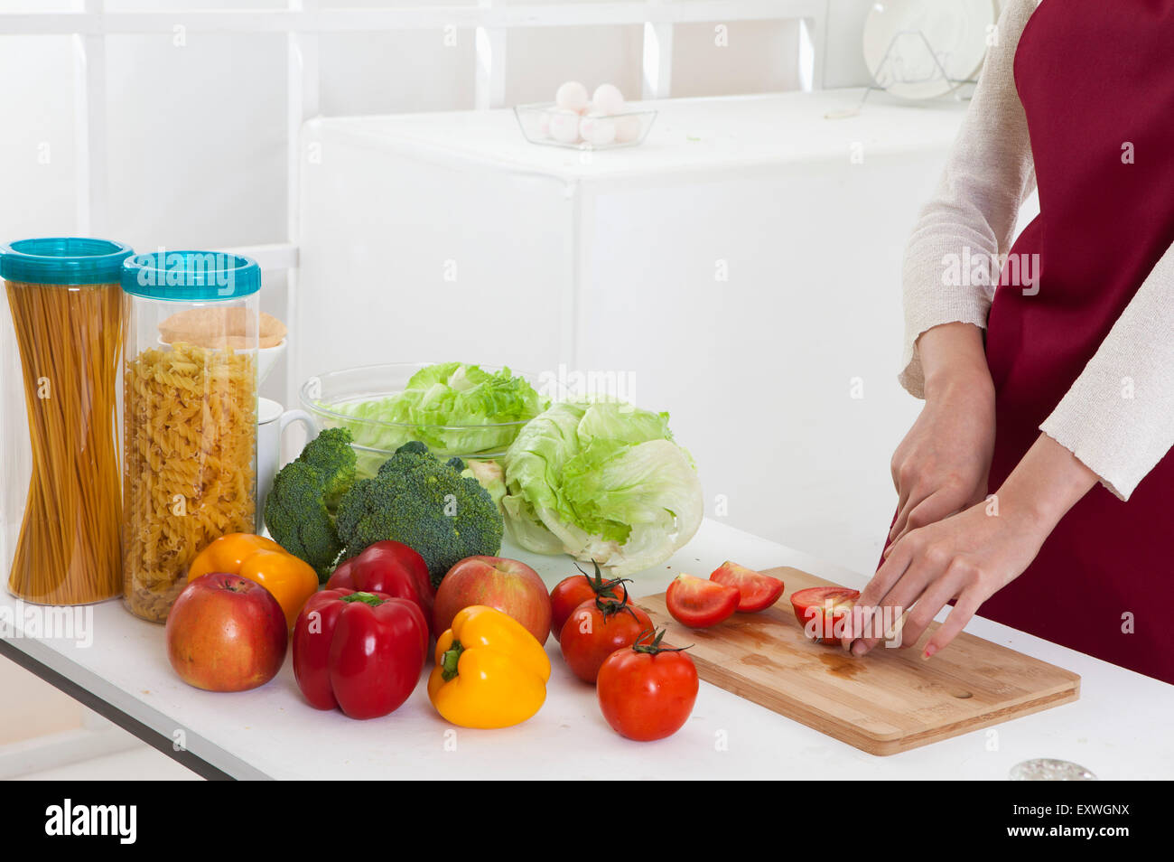 Young woman cutting vegetables in the kitchen Stock Photo - Alamy