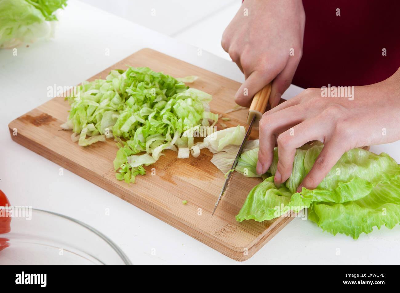 Young woman cutting vegetables in the kitchen Stock Photo - Alamy