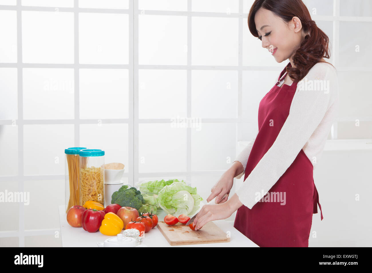 Young woman cutting vegetables in the kitchen Stock Photo - Alamy