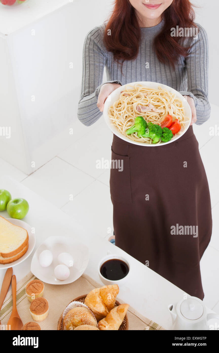 Young woman holding a plate of spaghetti with smile Stock Photo - Alamy