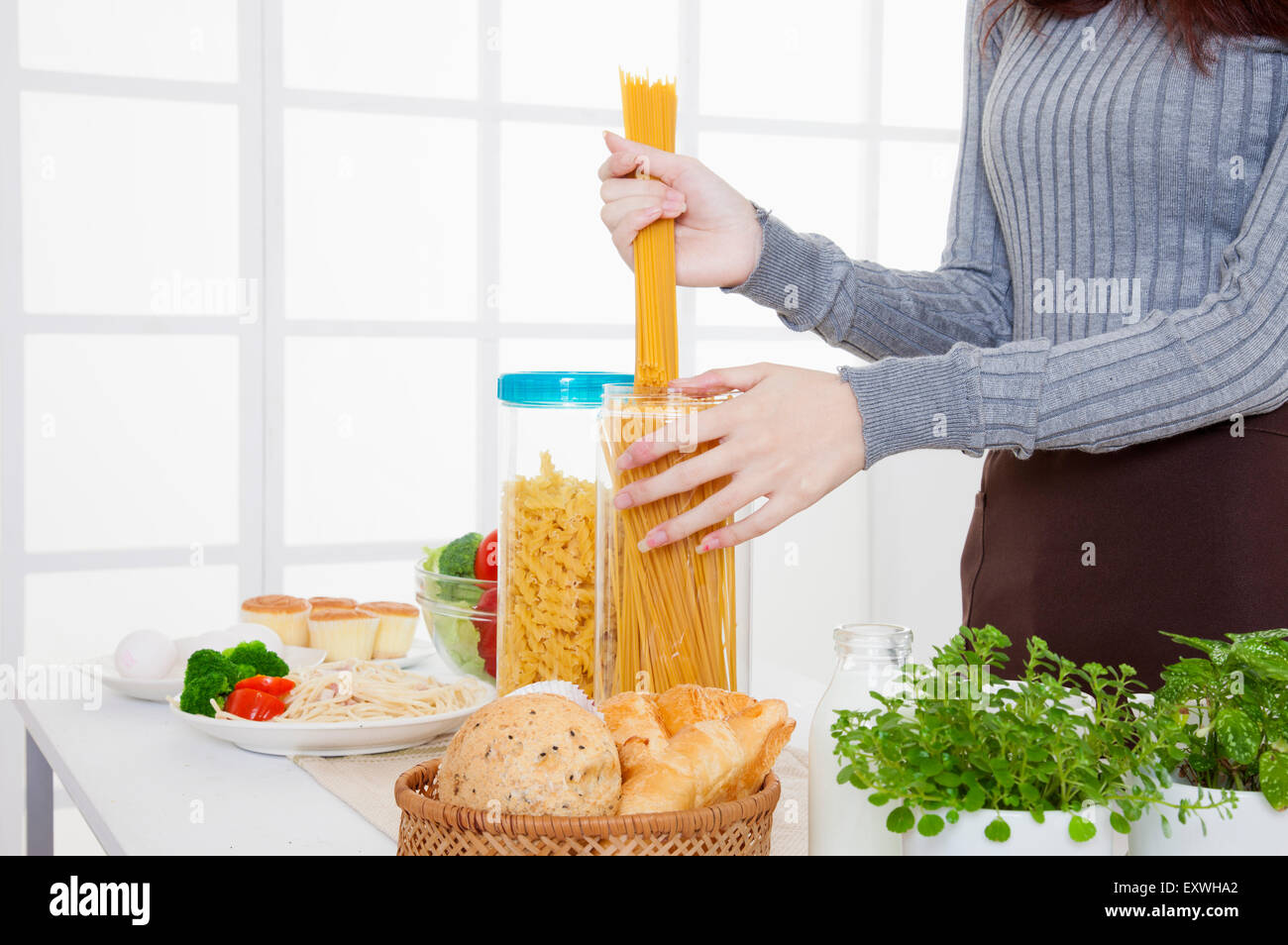 Young woman holding spaghetti in the kitchen Stock Photo - Alamy