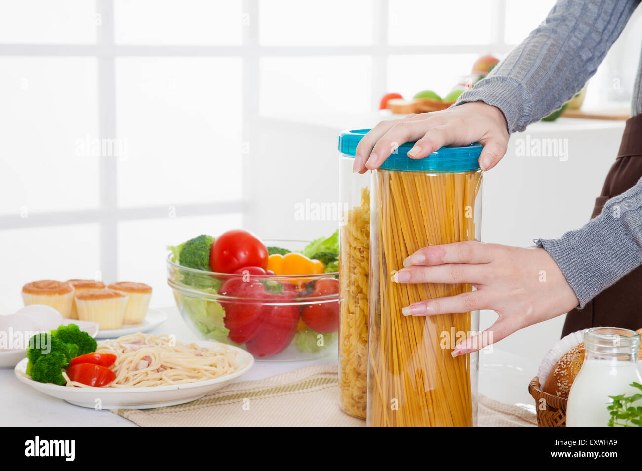 Young woman holding spaghetti in the kitchen Stock Photo - Alamy