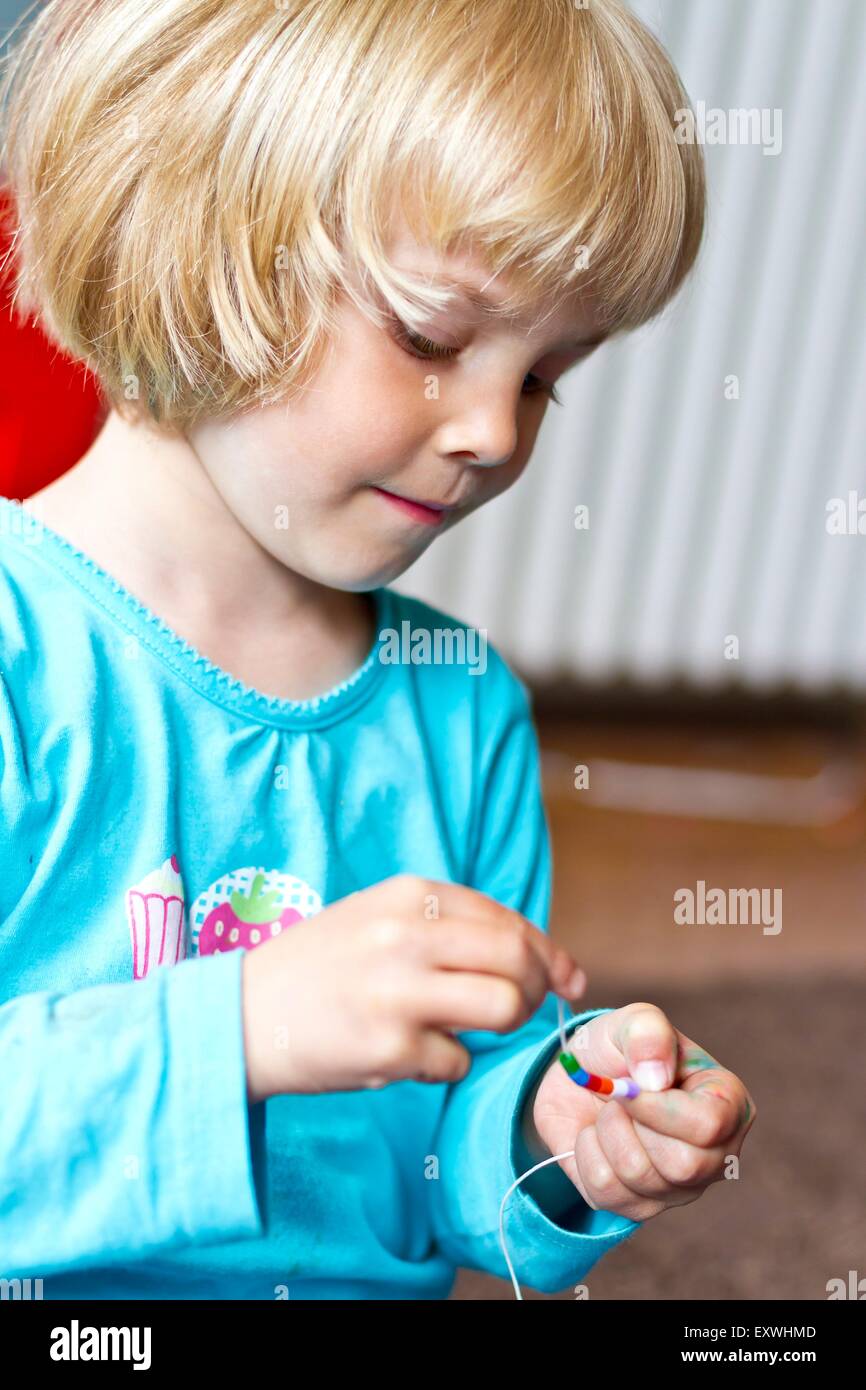 Girl threading the pearls Stock Photo - Alamy
