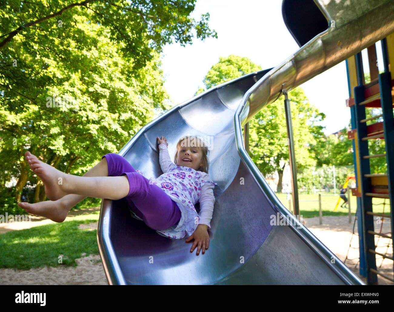Girl sliding on playground Stock Photo - Alamy