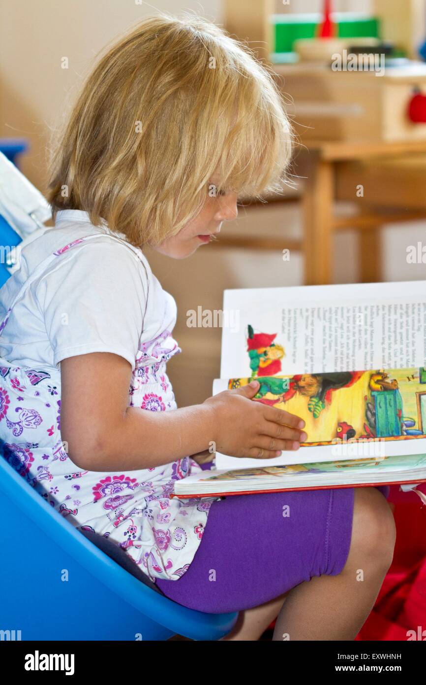 Girl reading in a book Stock Photo - Alamy