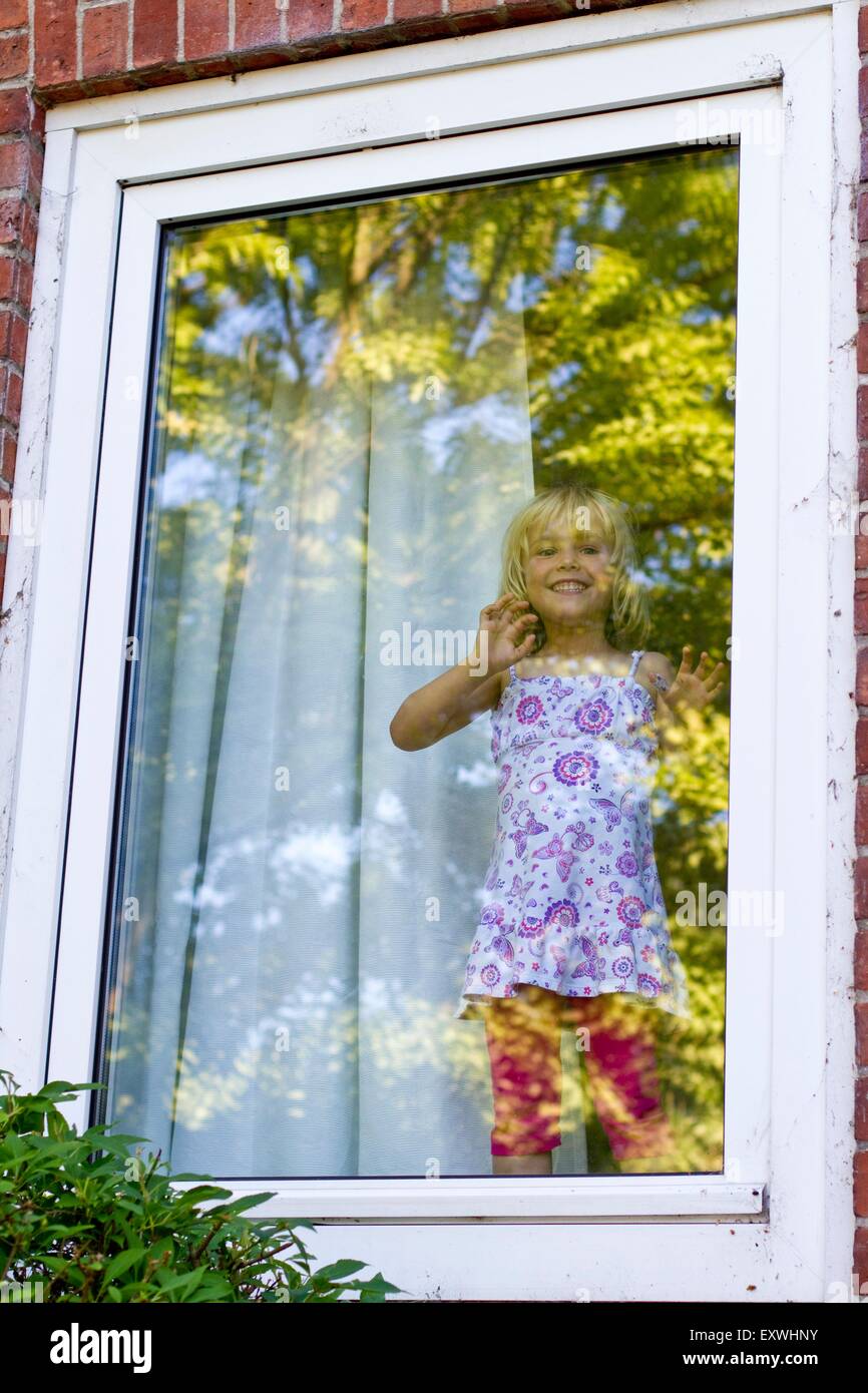 Girl standing at window Stock Photo - Alamy