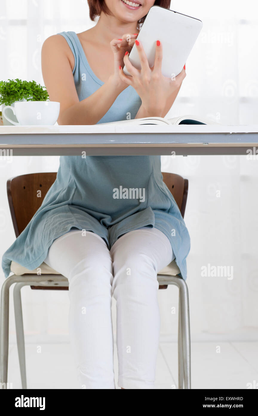 Young woman sitting and using touch pad with smile Stock Photo - Alamy