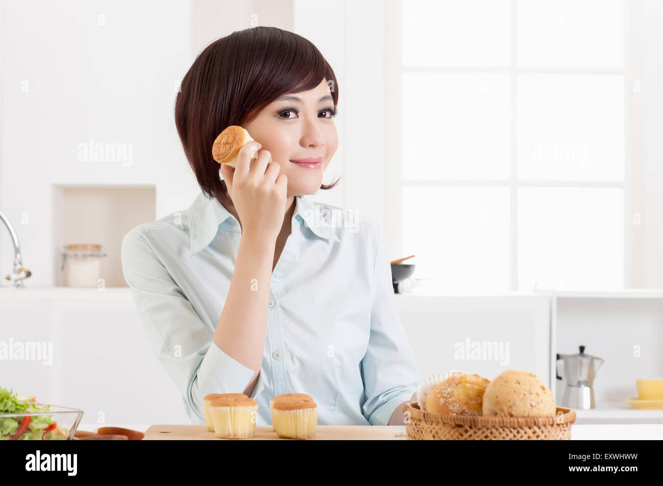 Young woman holding bread and looking away with smile Stock Photo - Alamy