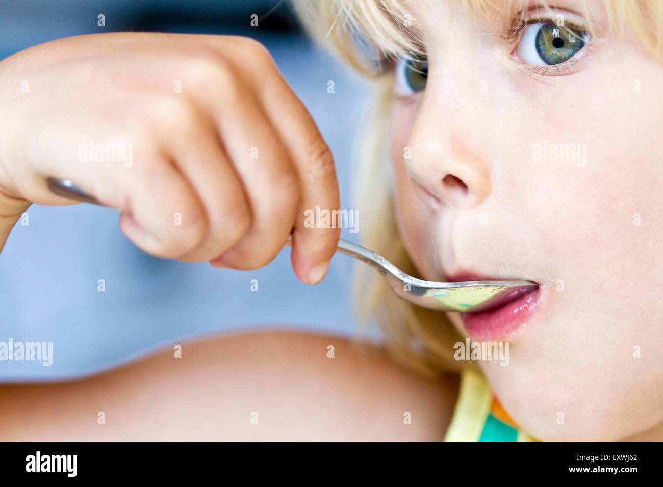 Girl eating with spoon Stock Photo - Alamy