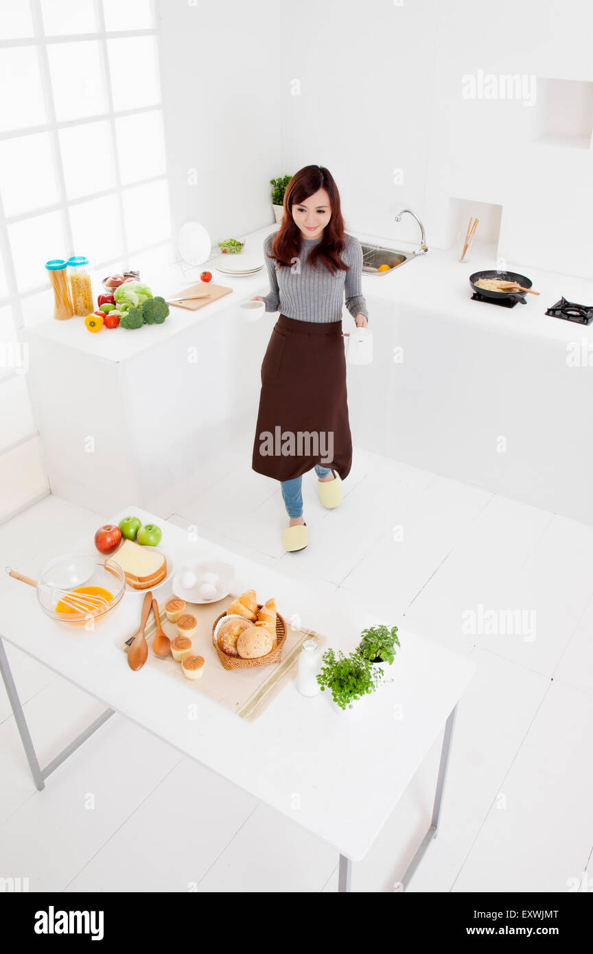 Young woman making breakfast Stock Photo - Alamy