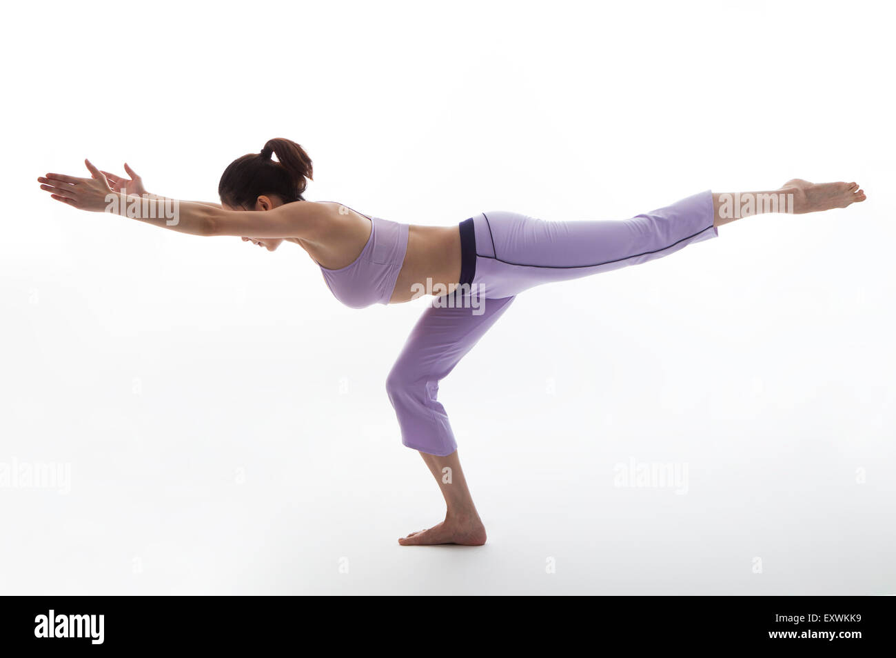 Woman practicing yoga and standing with one leg Stock Photo - Alamy