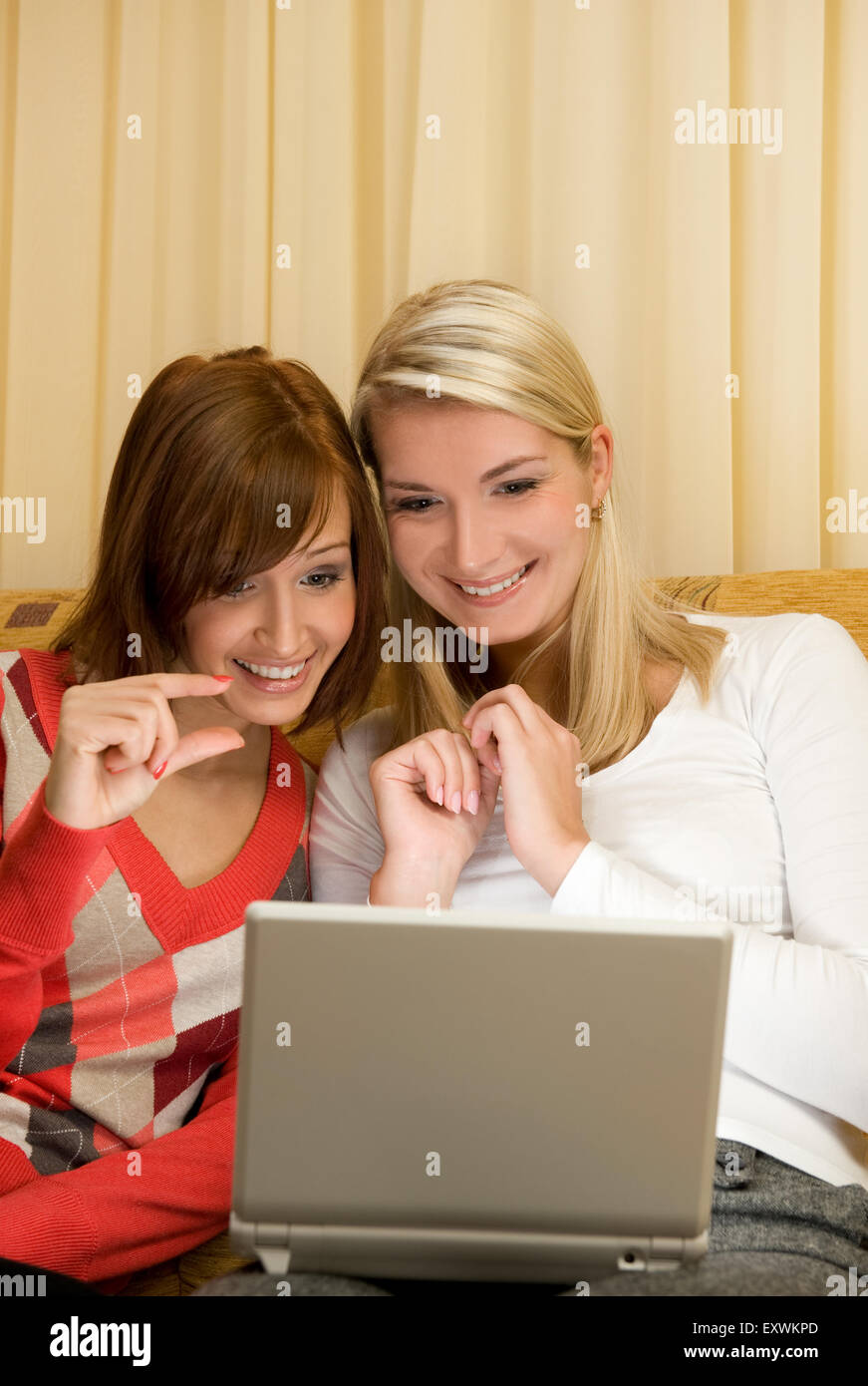Two beautiful women having fun working with on laptop Stock Photo - Alamy