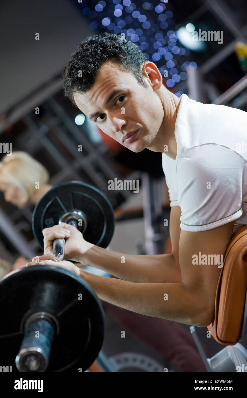 Handsome young man lifting weight in a gym Stock Photo - Alamy