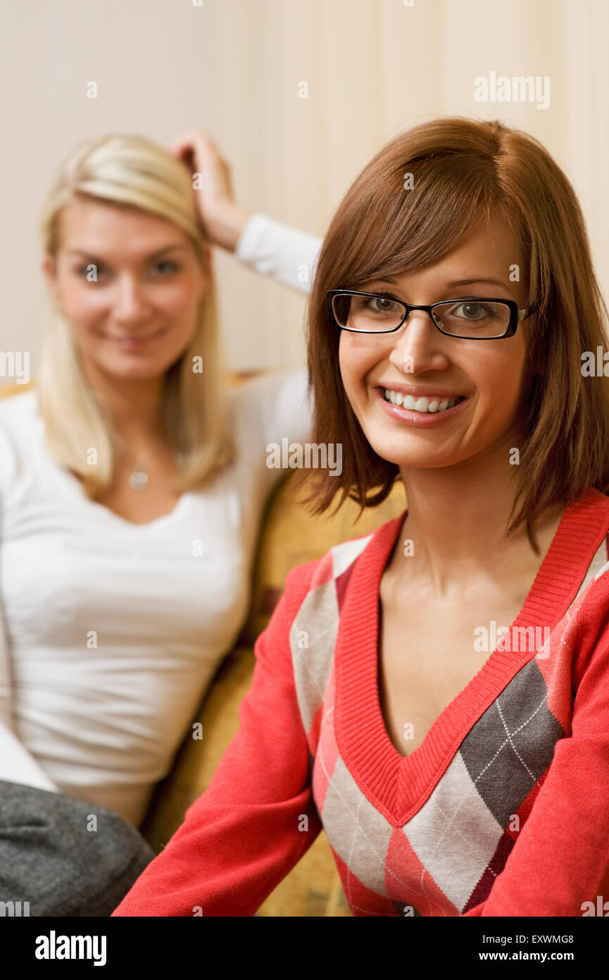 Two friends sitting on sofa Stock Photo - Alamy