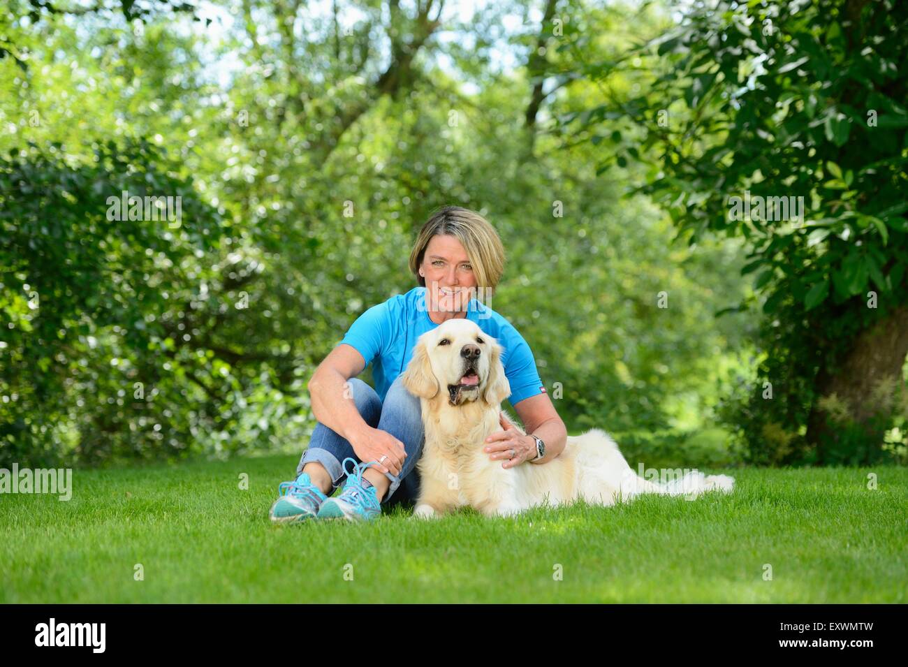 Mature woman with a golden retriever in garden Stock Photo - Alamy