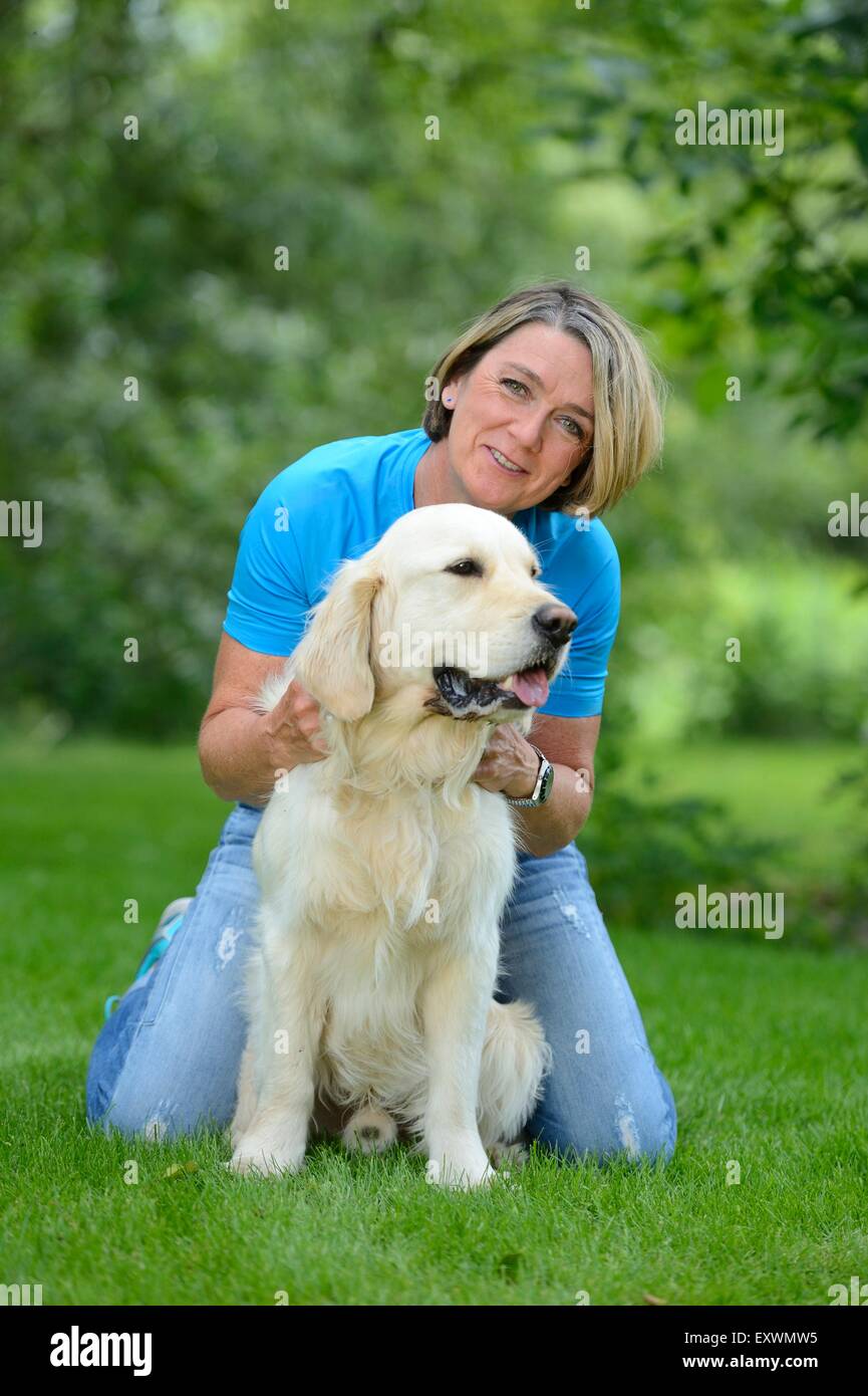 Mature woman with a golden retriever in garden Stock Photo - Alamy