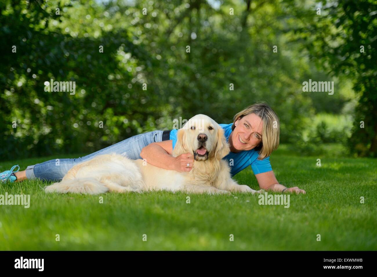 Mature woman with a golden retriever in garden Stock Photo - Alamy