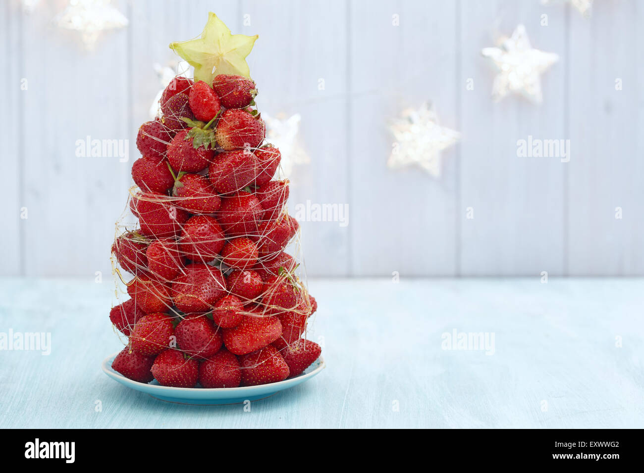 Strawberry Christmas tree with star fruit and caramel Stock Photo - Alamy
