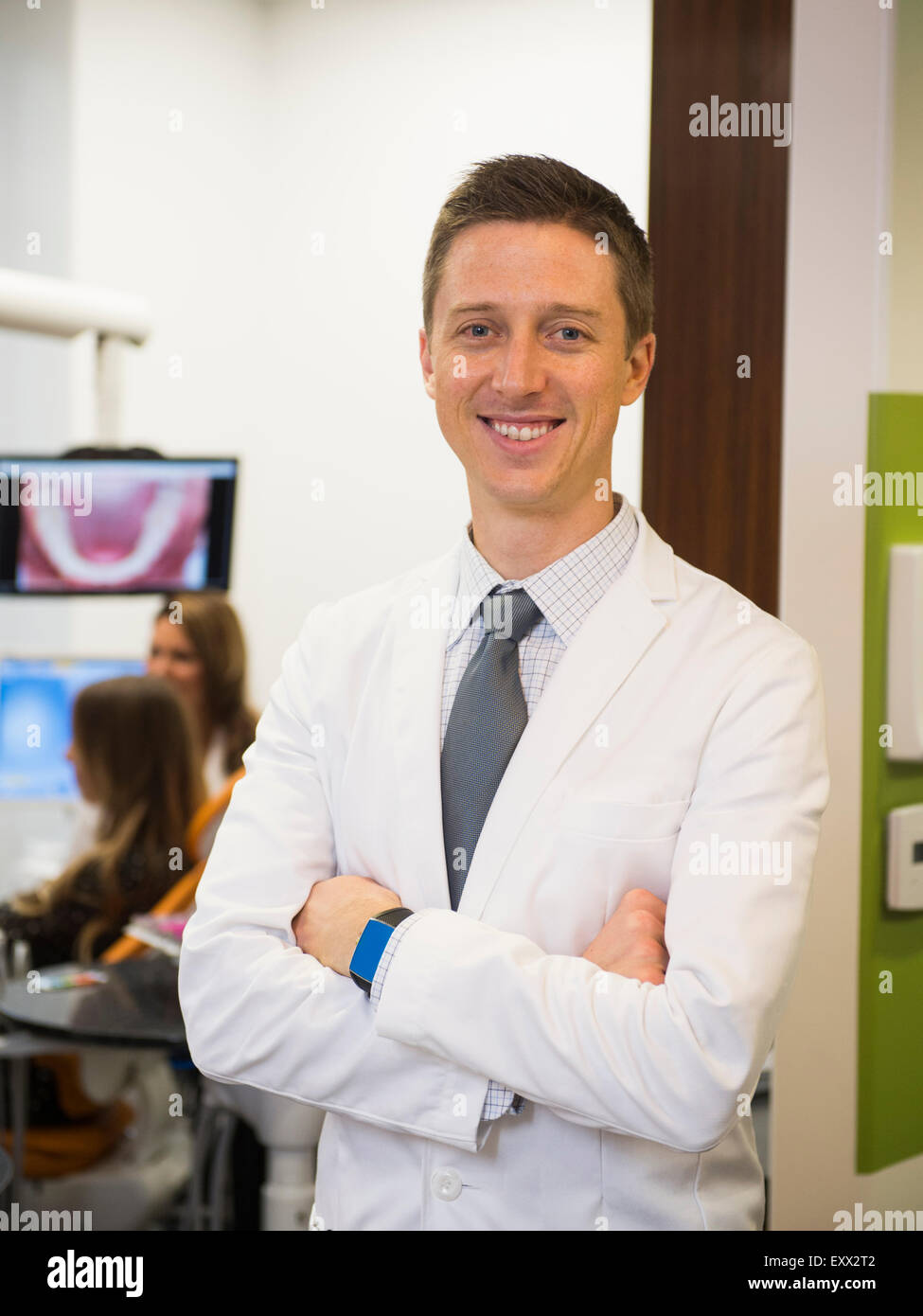 Portrait of dentist with colleague and patient in background Stock ...
