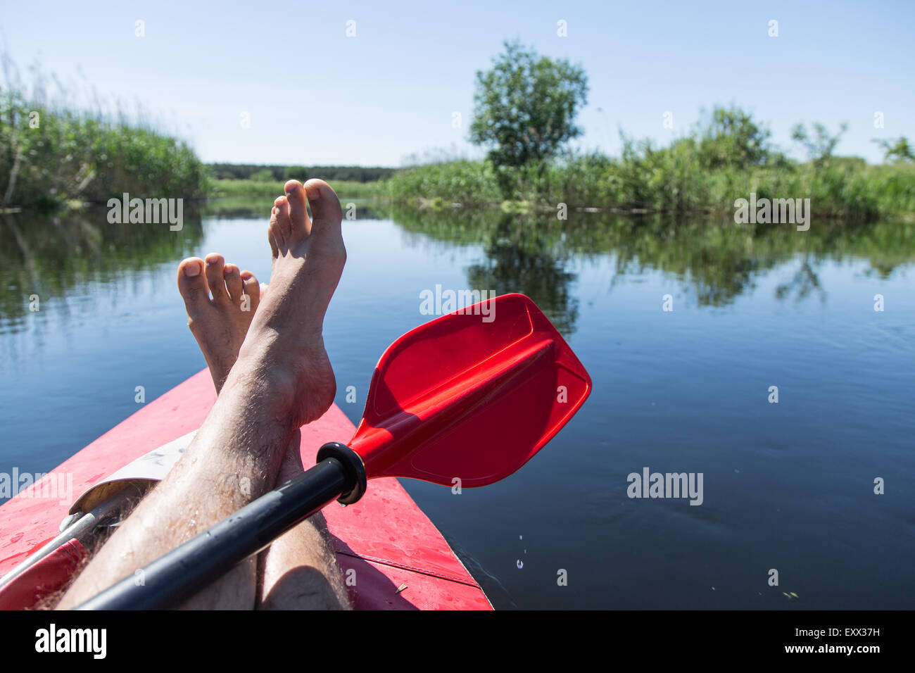 Man's legs over canoe. Resting time Stock Photo - Alamy