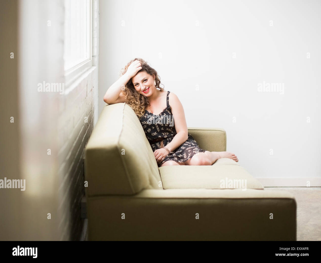 Woman seated on sofa in interior hi-res stock photography and images ...