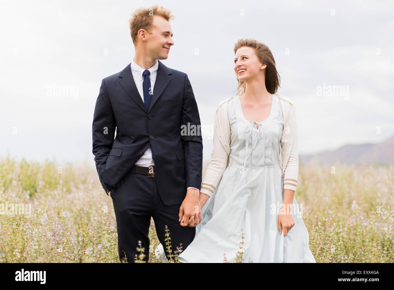 Newlywed couple in field Stock Photo - Alamy