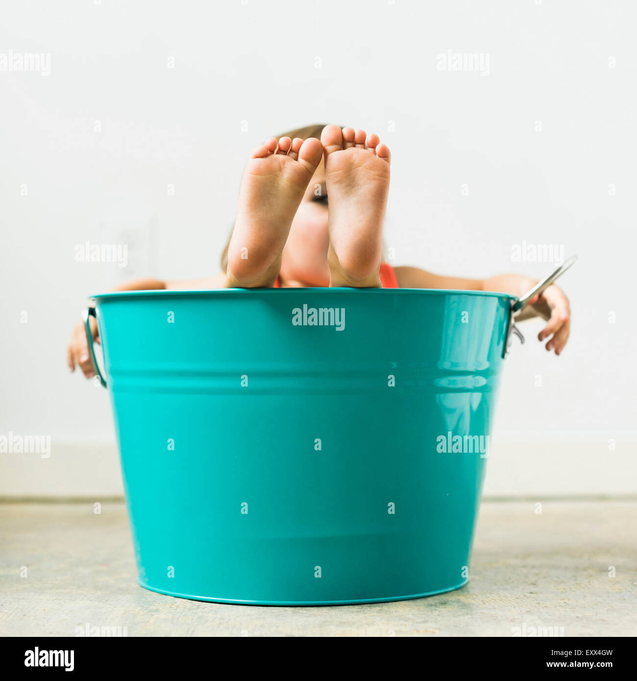 Little girl (2-3) sitting in turquoise bucket Stock Photo - Alamy