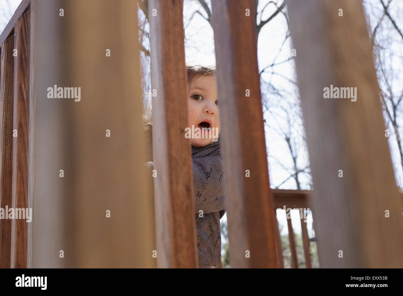 Portrait of girl hiding behind fence Stock Photo - Alamy