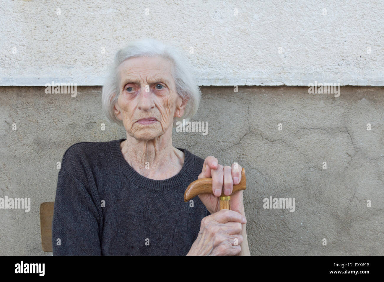 Portrait of a ninety years old grandma with walking stick sitting ...