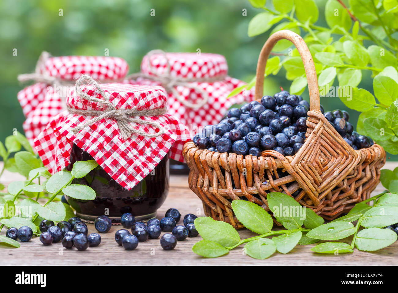 Basket with blueberries and three jars of jam Stock Photo - Alamy
