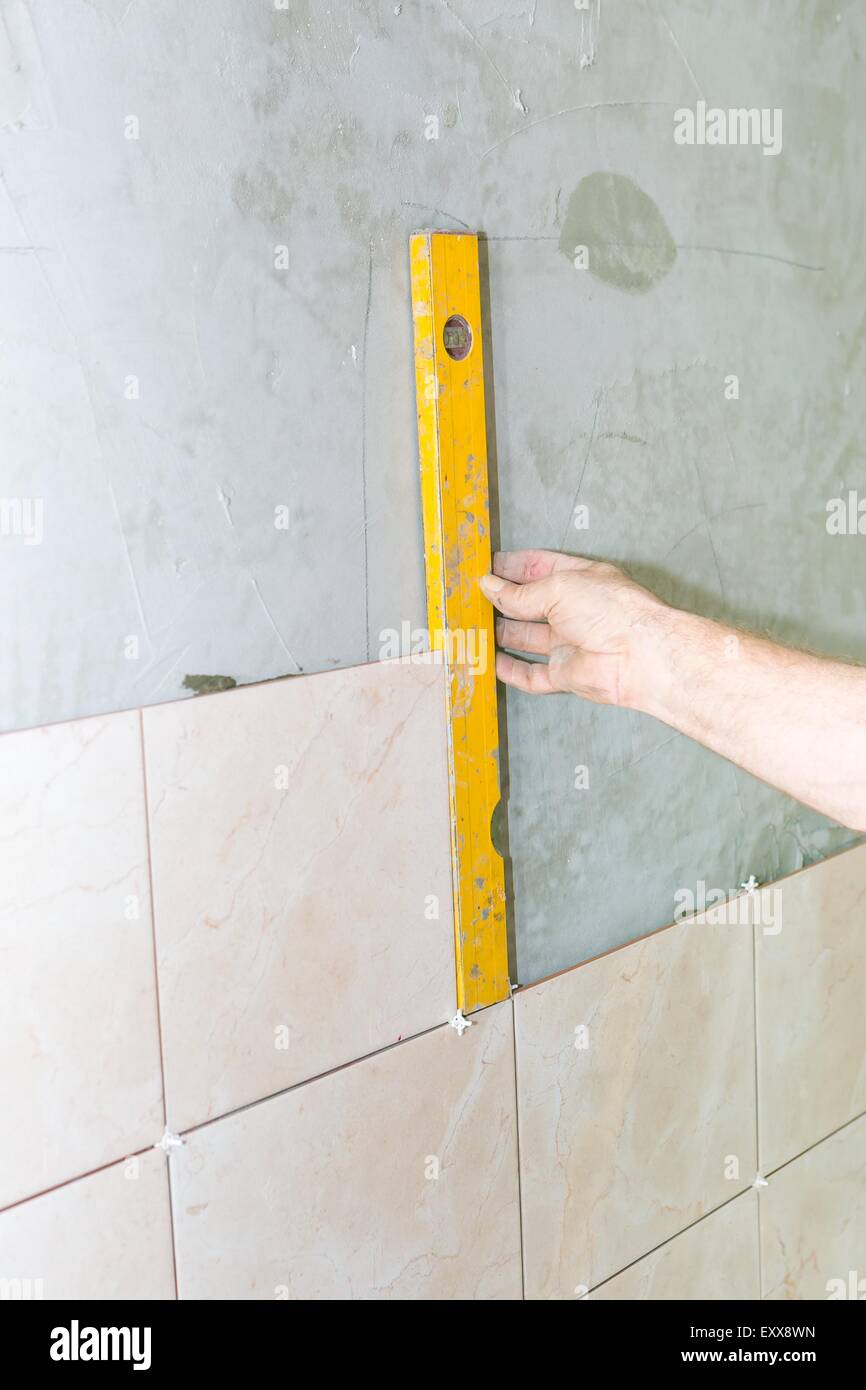 Hand of worker with spirit level. repair, building, technology and home ...