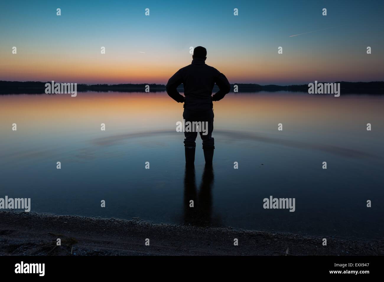Man in lake water at sunset. Beautiful sunset with man silhouette Stock ...