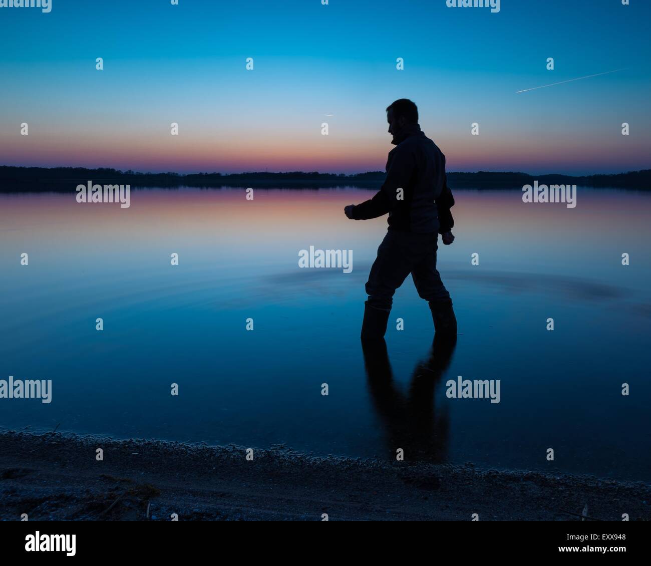 Man in lake water at sunset. Beautiful sunset with man silhouette Stock ...