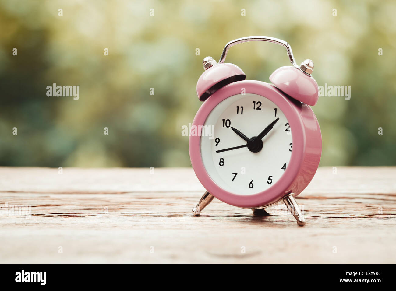 Vintage stylized photo of alarm clock on wooden table Stock Photo - Alamy
