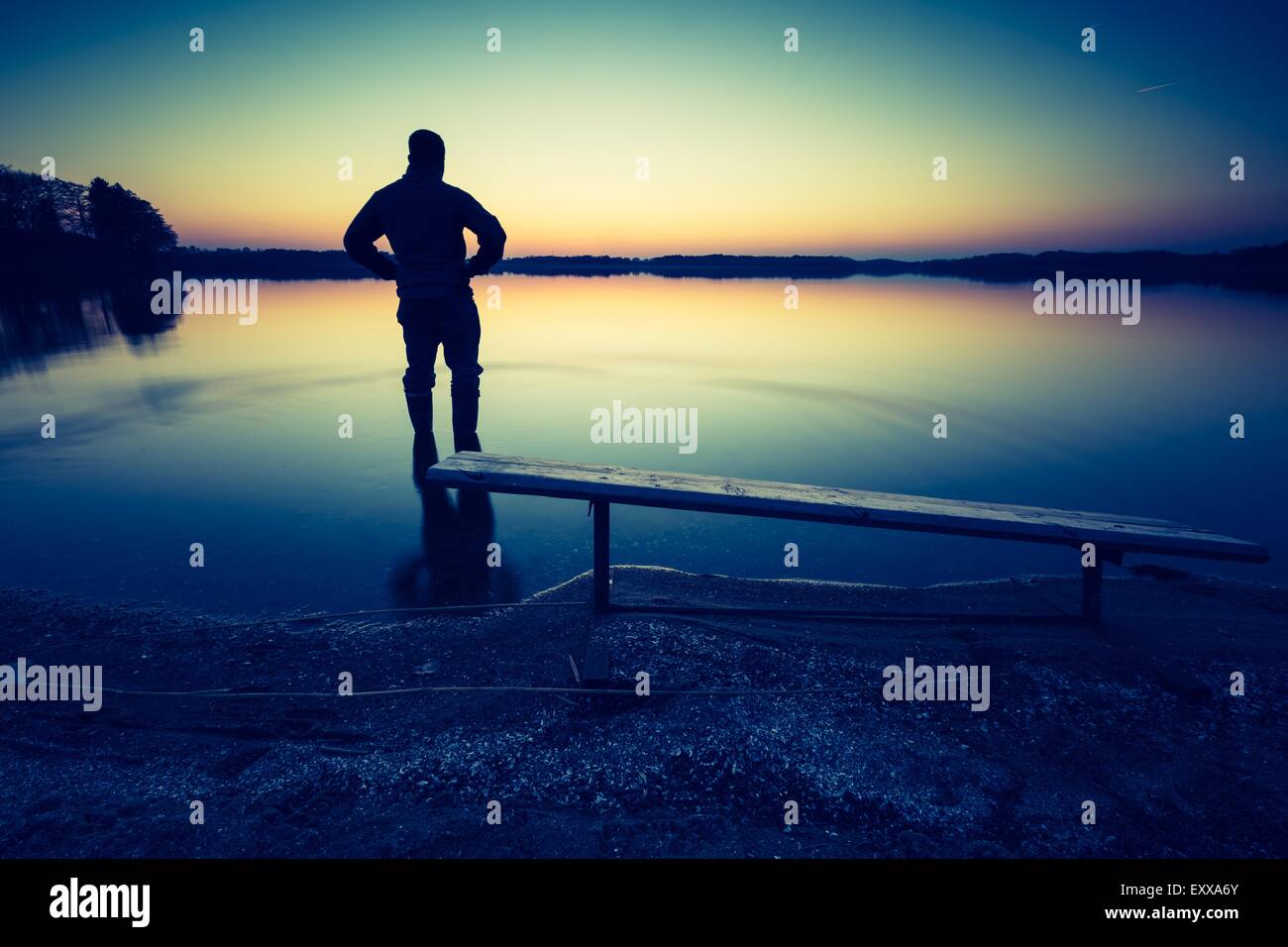 Man in lake water at sunset. Beautiful sunset with man silhouette Stock ...