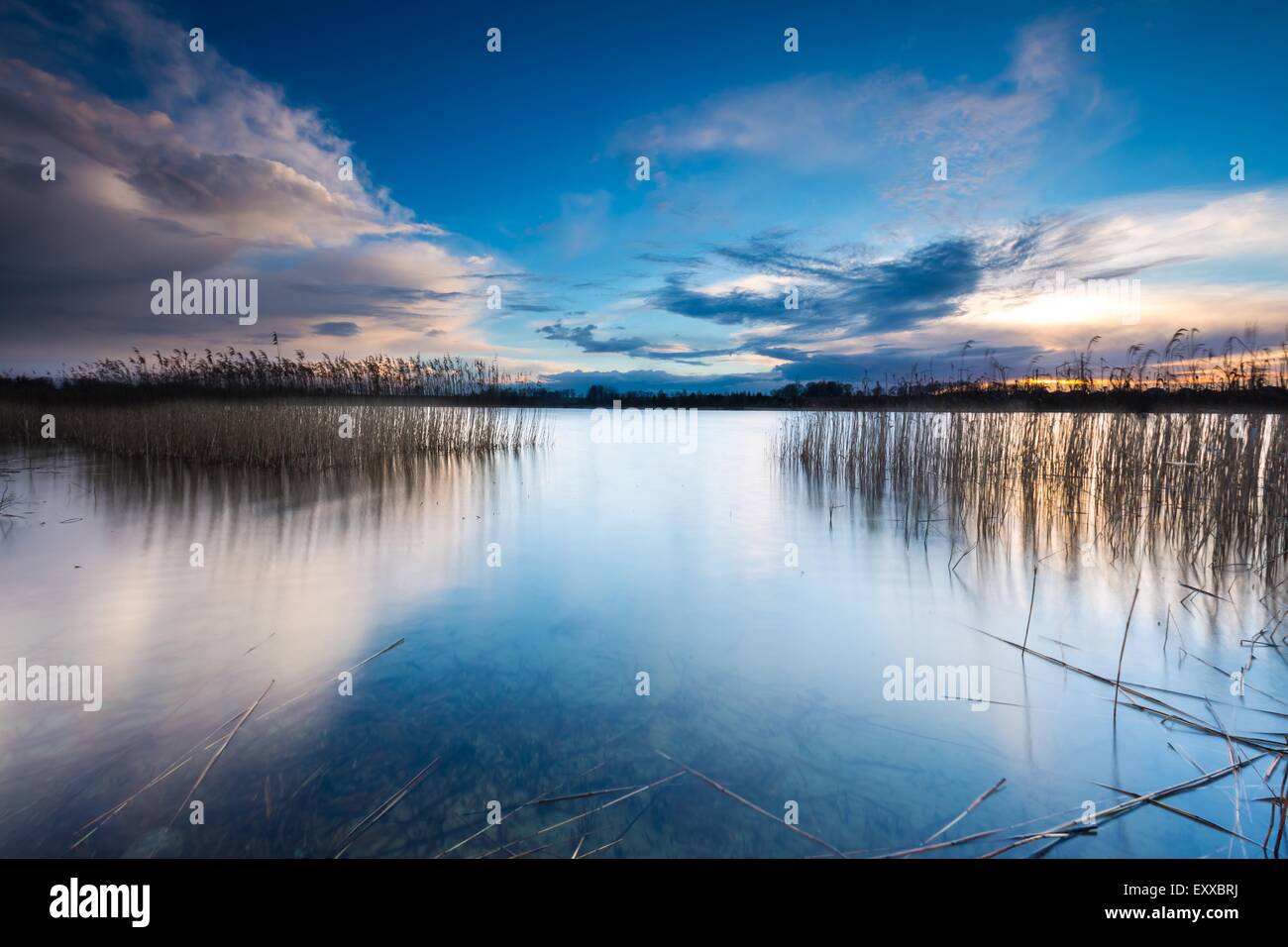 Beautiful sunset over calm lake in Mazury lake district. After sunset ...