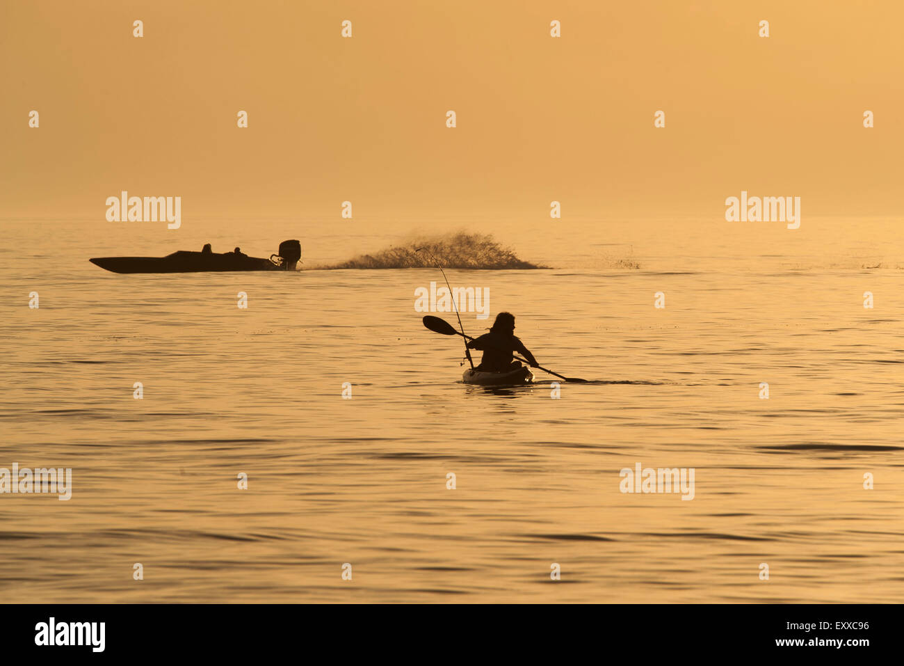 Person kayaking at sunset Stock Photo - Alamy