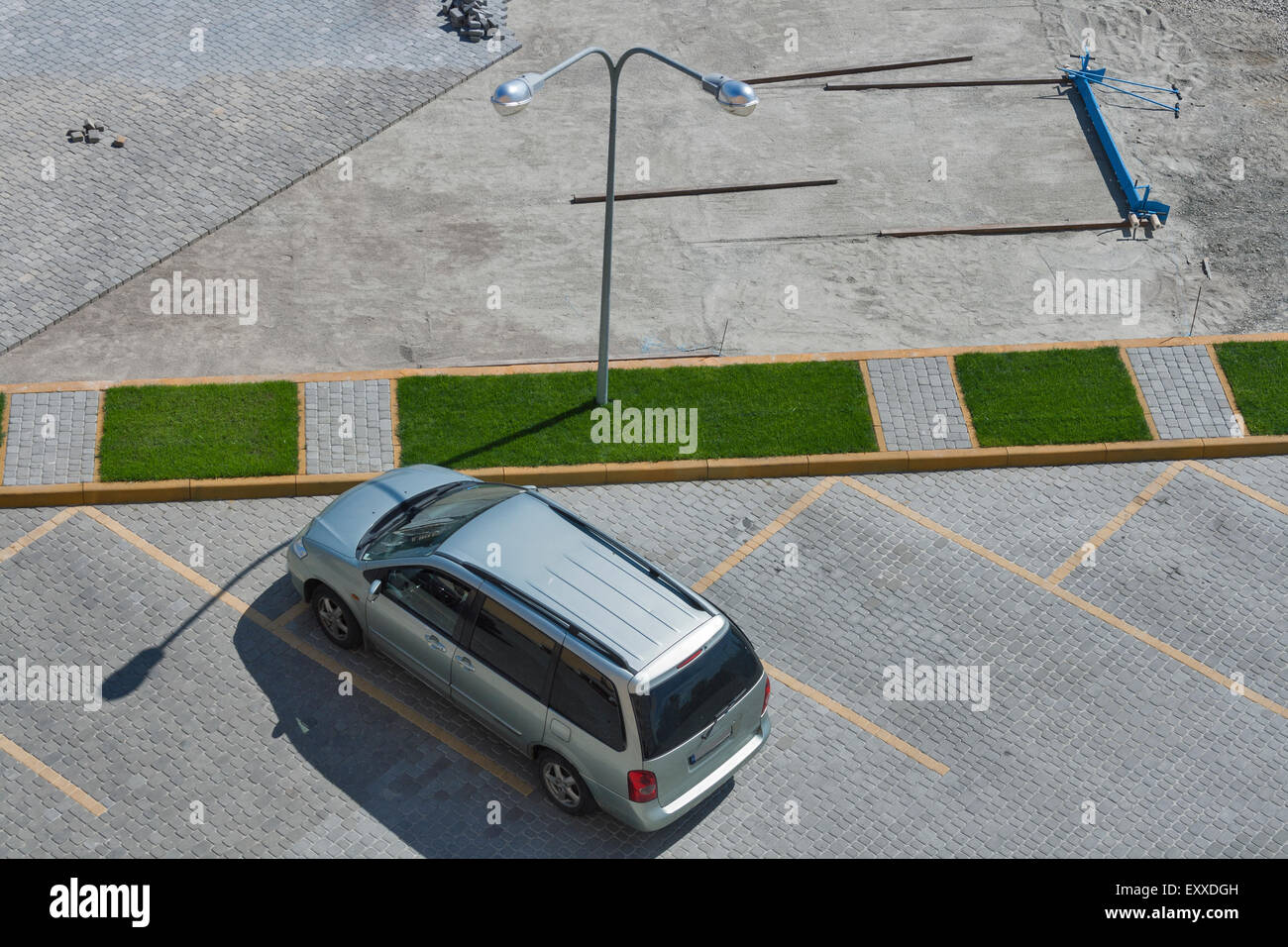 Pavement parking lot construction with car, green grass and street lamp ...