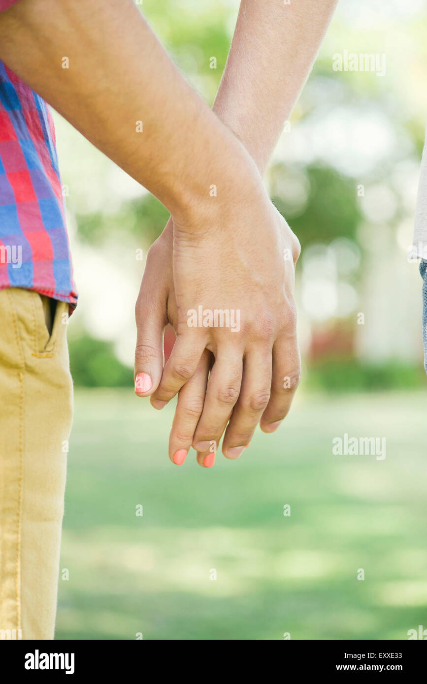 Couple holding hands outdoors, cropped rear view Stock Photo - Alamy