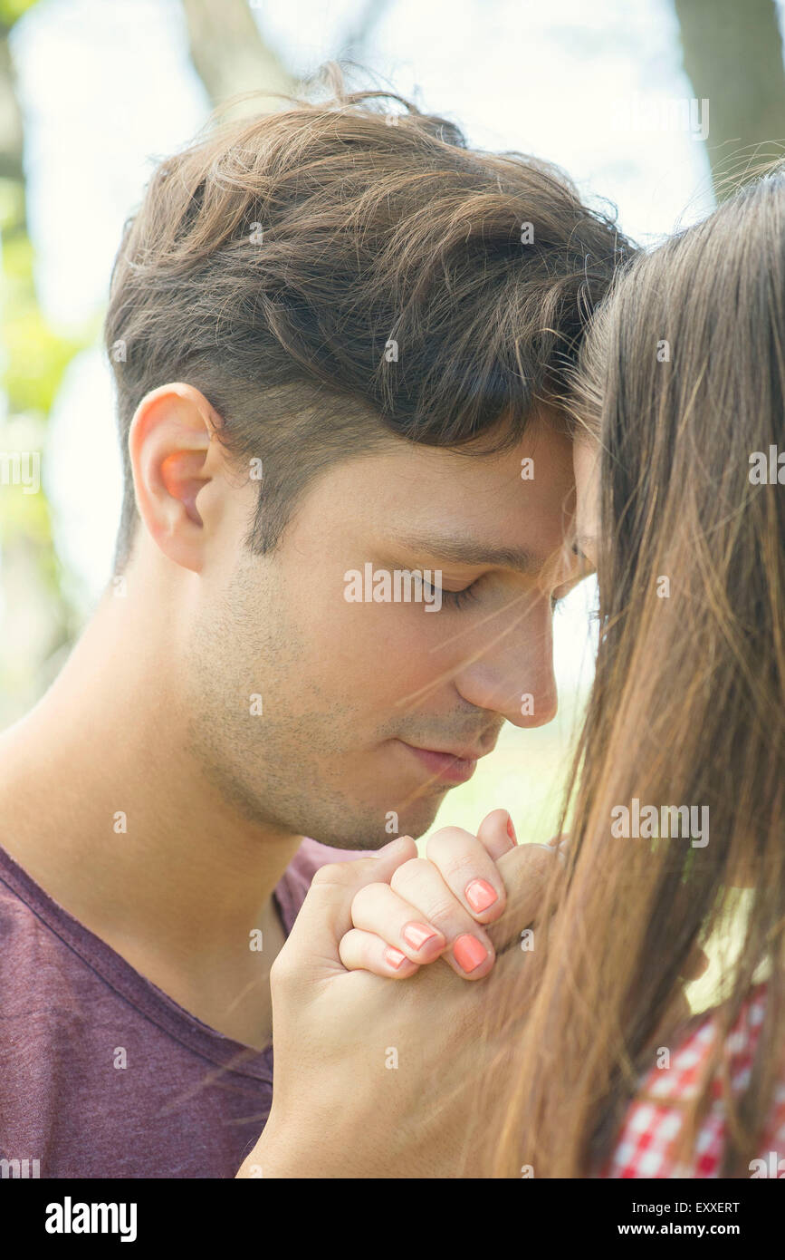 Couple touching foreheads and holding hands outdoors Stock Photo - Alamy