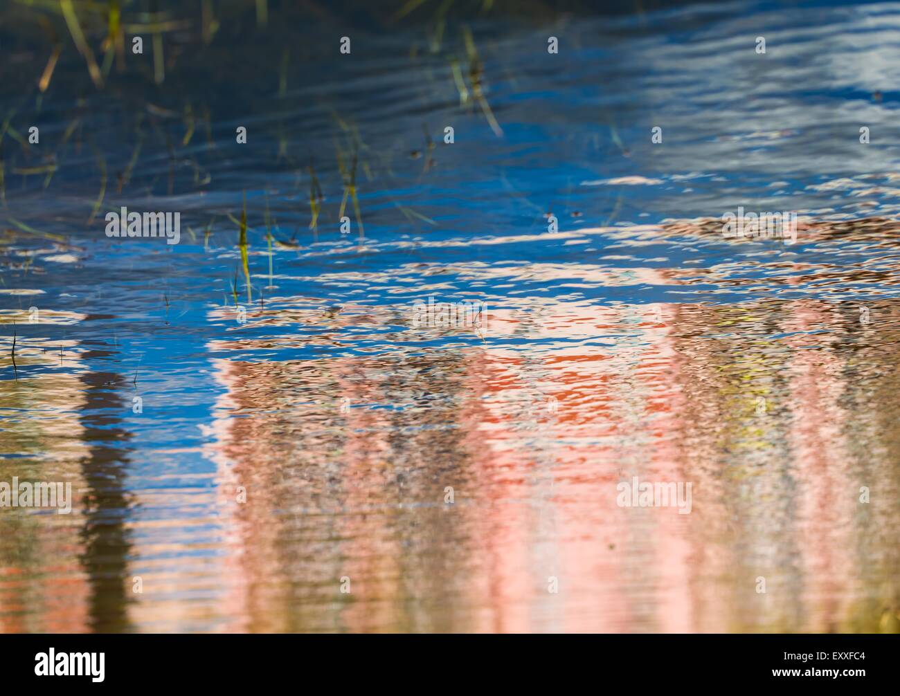 close up of water surface with ripples. sky with clouds, building or ...
