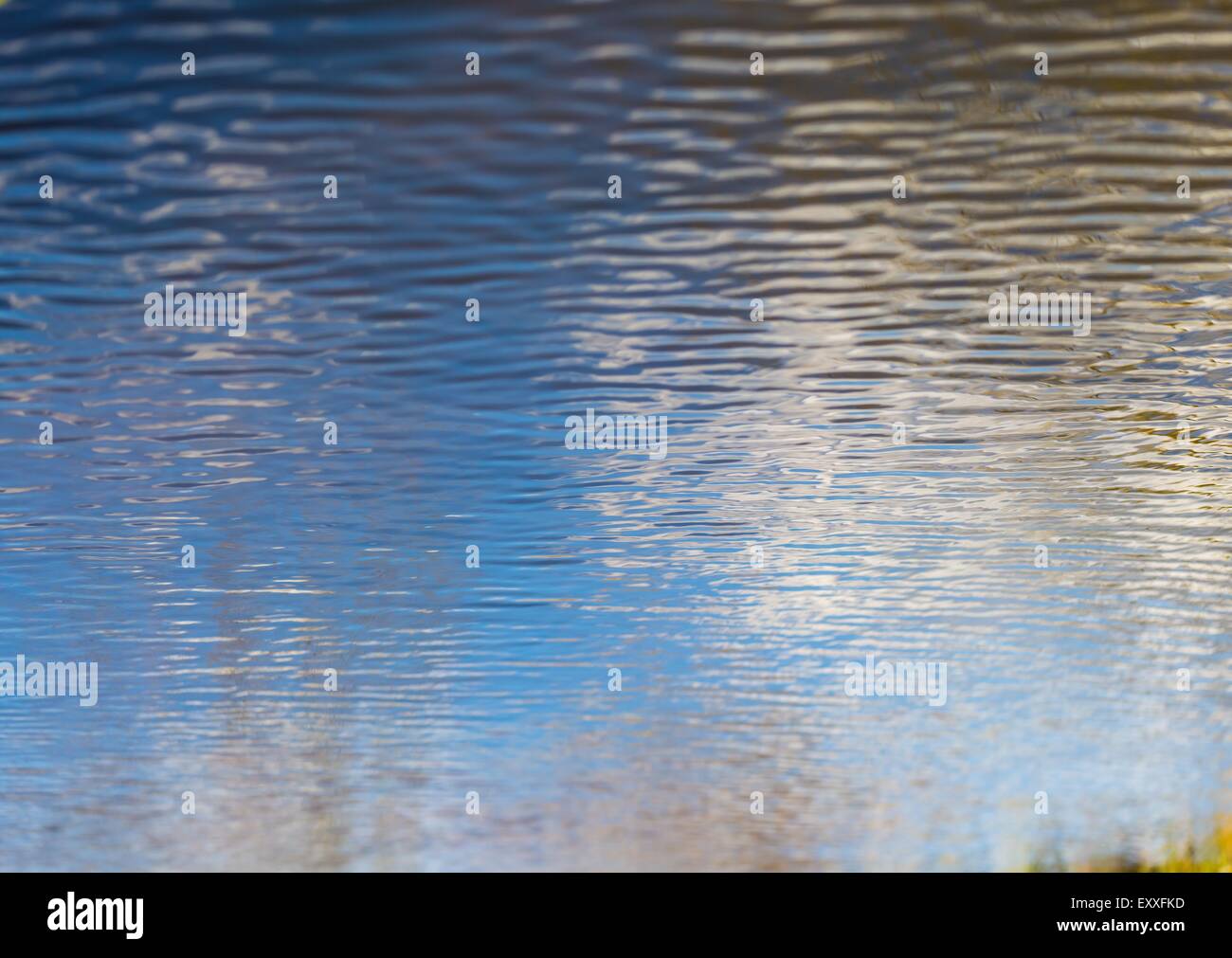 close up of water surface with ripples. sky with clouds, building or ...