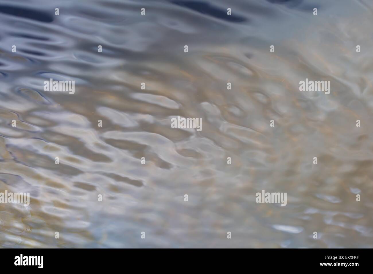 close up of water surface with ripples. sky with clouds, building or ...