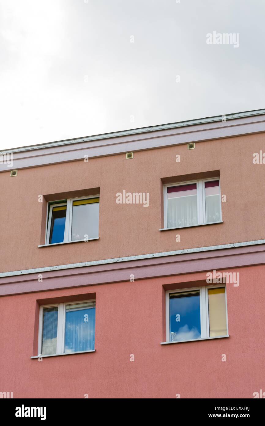 Close up of top part of block of flats building with blue sky ...