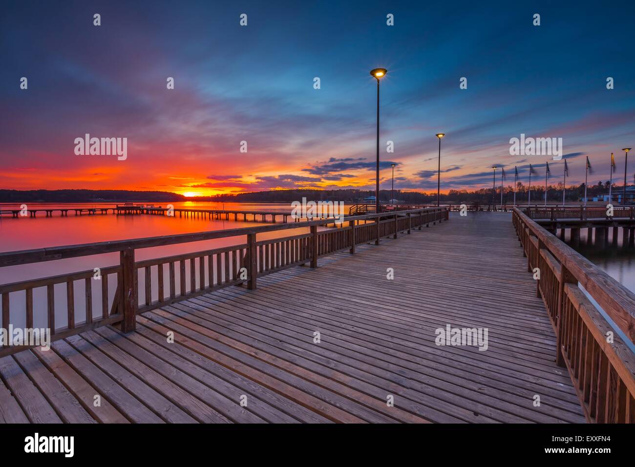 Beautiful lake landscape with vibrant sunset and pier. Long exposure ...