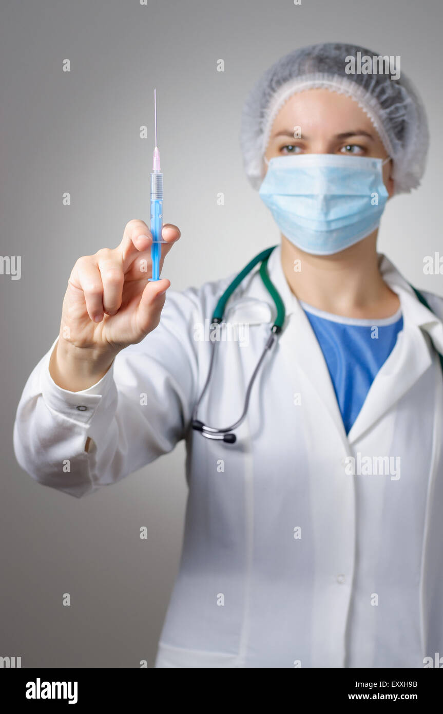 Female doctor with syringe and face mask Stock Photo - Alamy