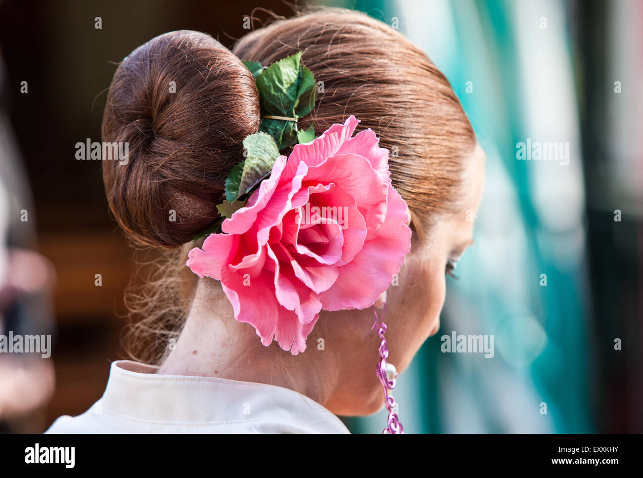 In traditional Seville dress and huge flower in hair in Seville ...
