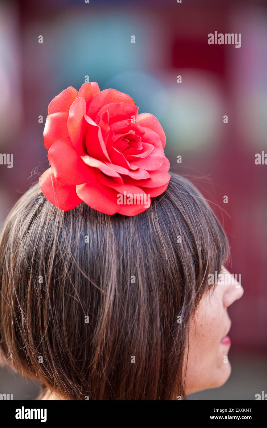 In traditional Seville dress and huge flower in hair in Seville ...