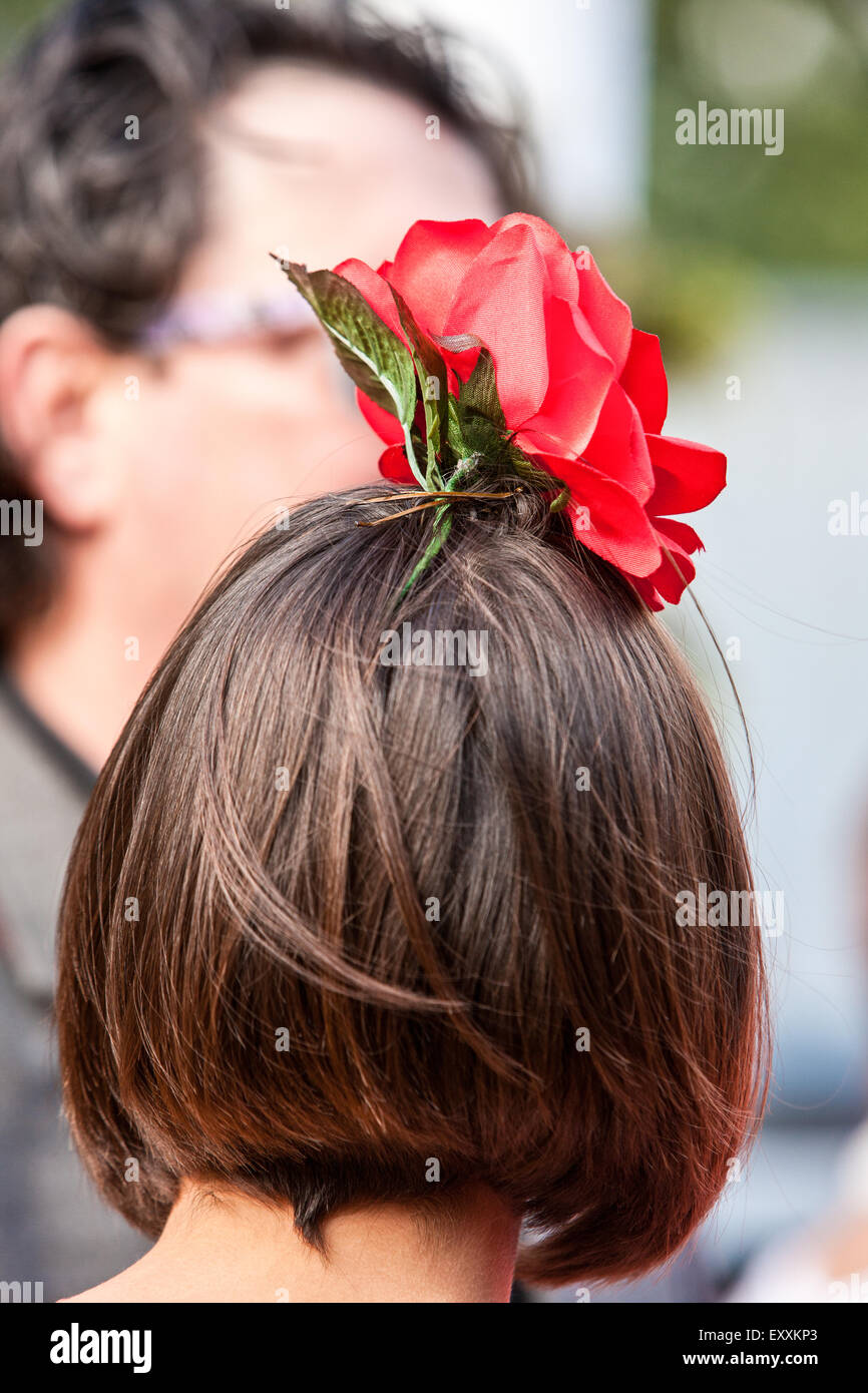 In traditional Seville dress and huge flower in hair in Seville ...